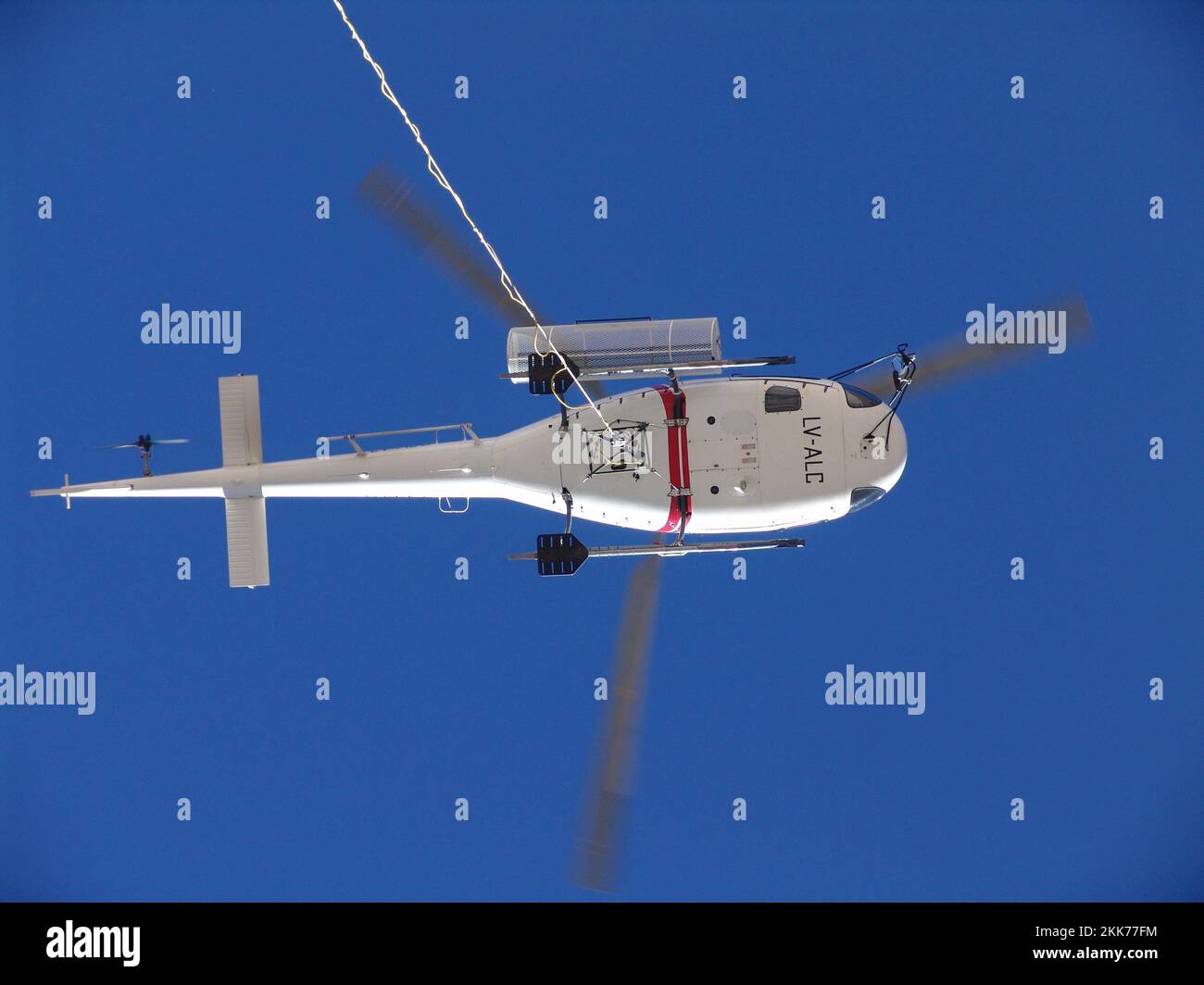 A low-angle view of a LV-ALC Airbus Helicopter picking up waste under a ...