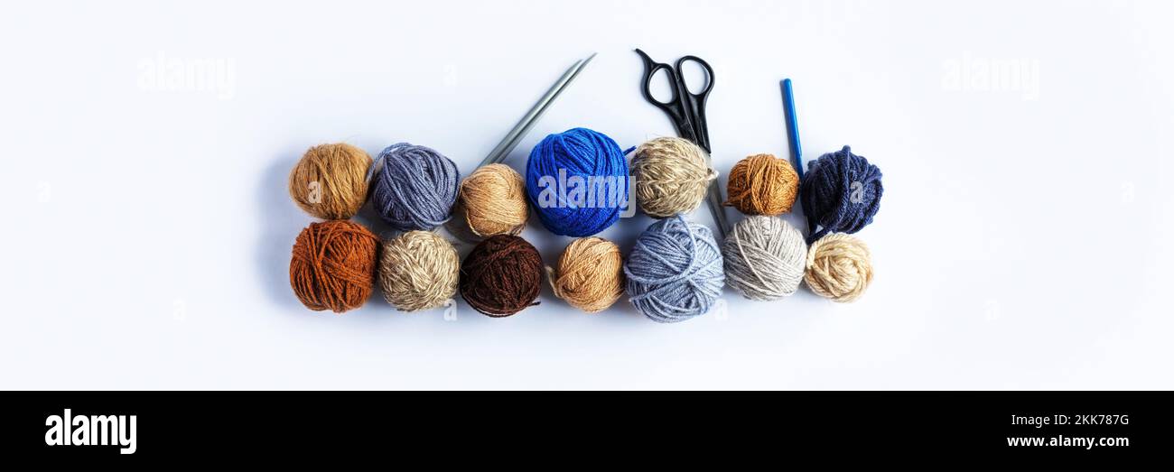 Blue, gray and brown balls of knitting thread with scissors, crochet ...