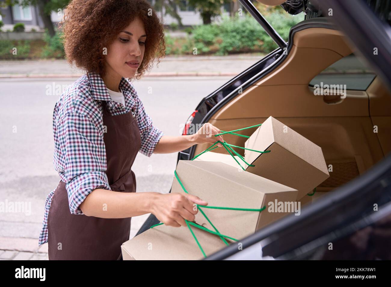 Young female loading car with products for customers Stock Photo - Alamy