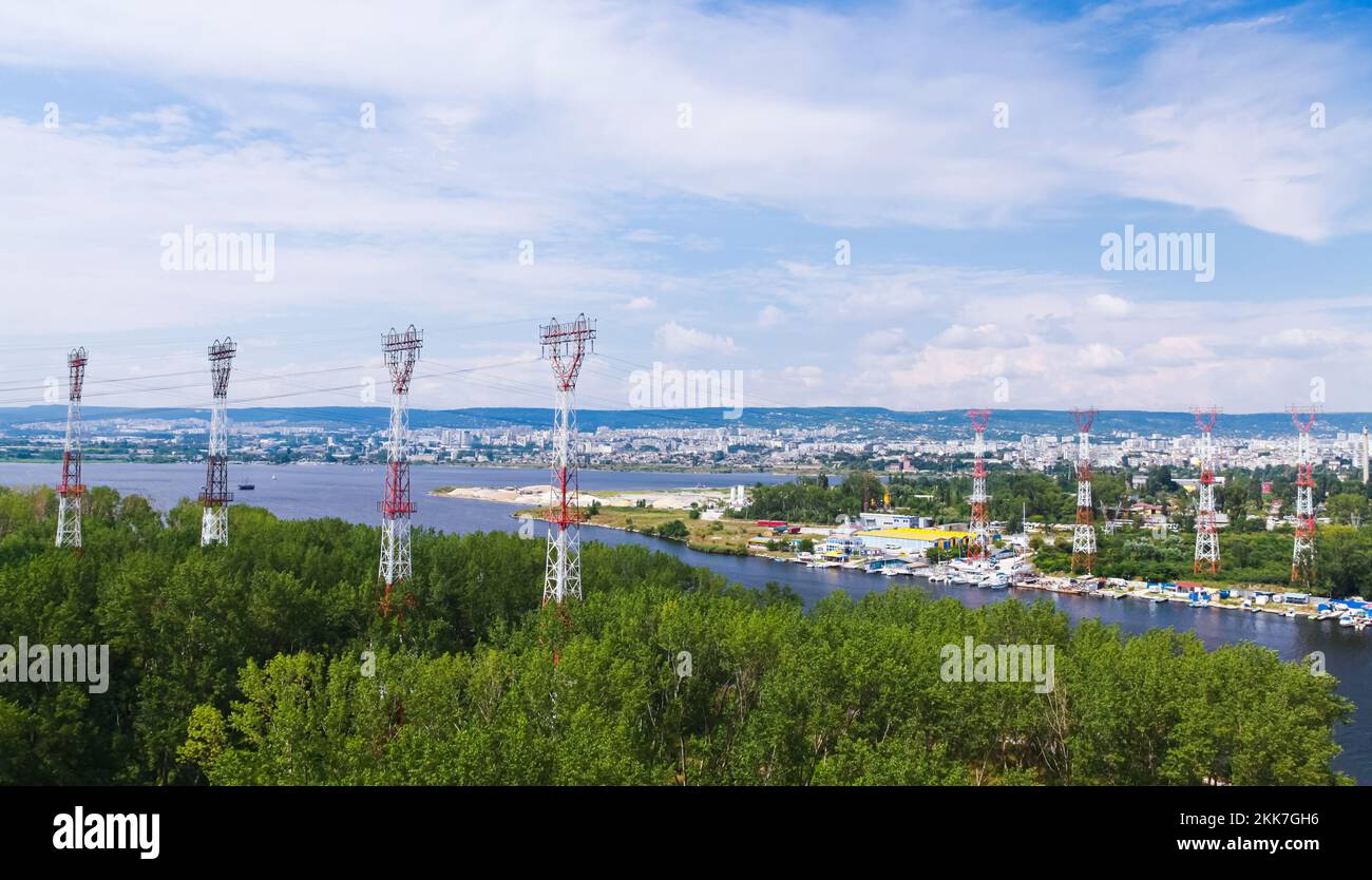 High-voltage power line goes over Varna lake. Red white truss poles ...