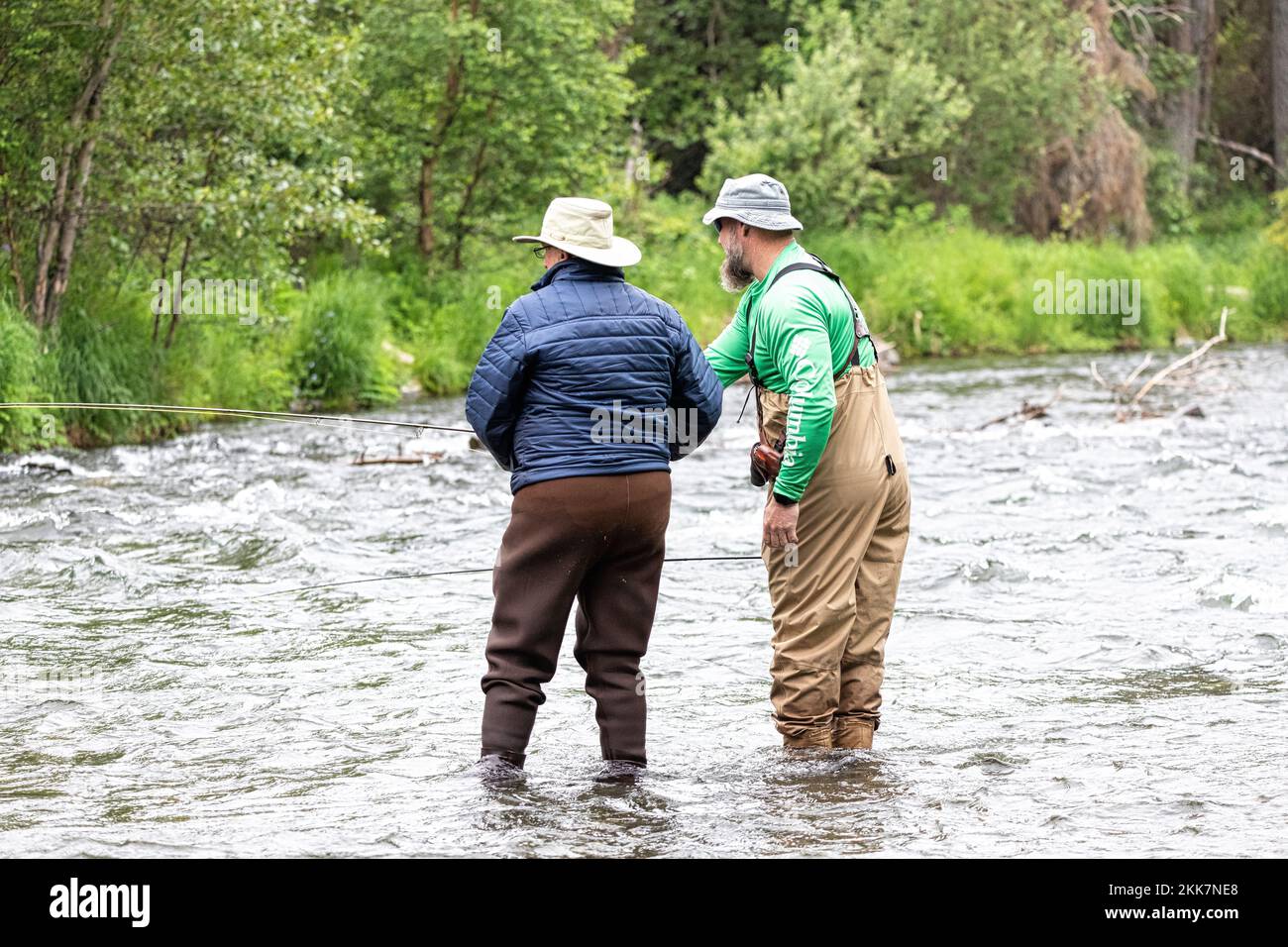 A rear closeup of two men enjoying fishing on Monnow Valley Fishery ...