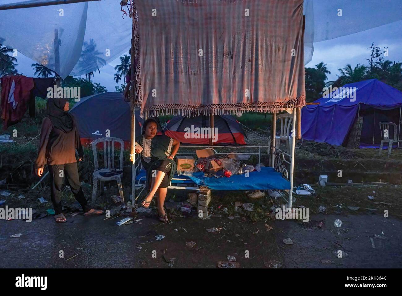 A woman sits on a bench around the earthquake refugees' tents in ...