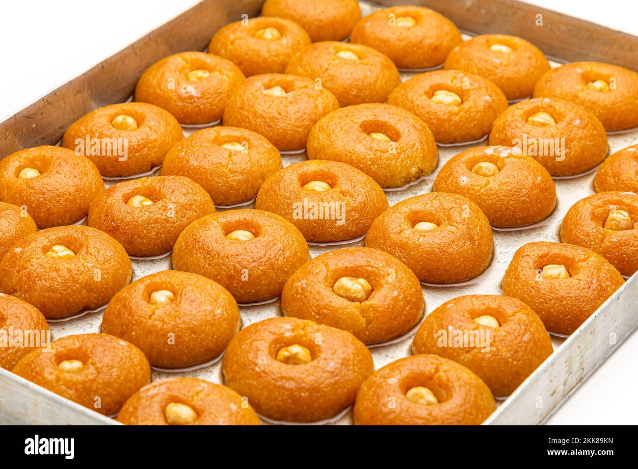 A closeup of a tray of a Turkish dessert called sekerpare on a white ...