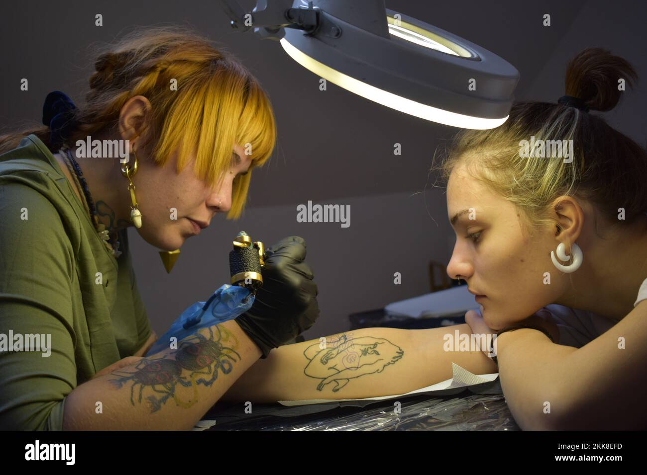 Tattoo artist tattooing a woman Stock Photo - Alamy