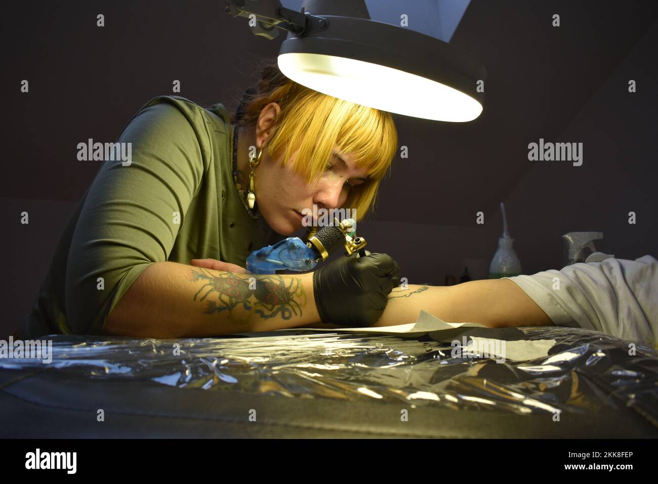 Tattoo artist tattooing a woman Stock Photo - Alamy