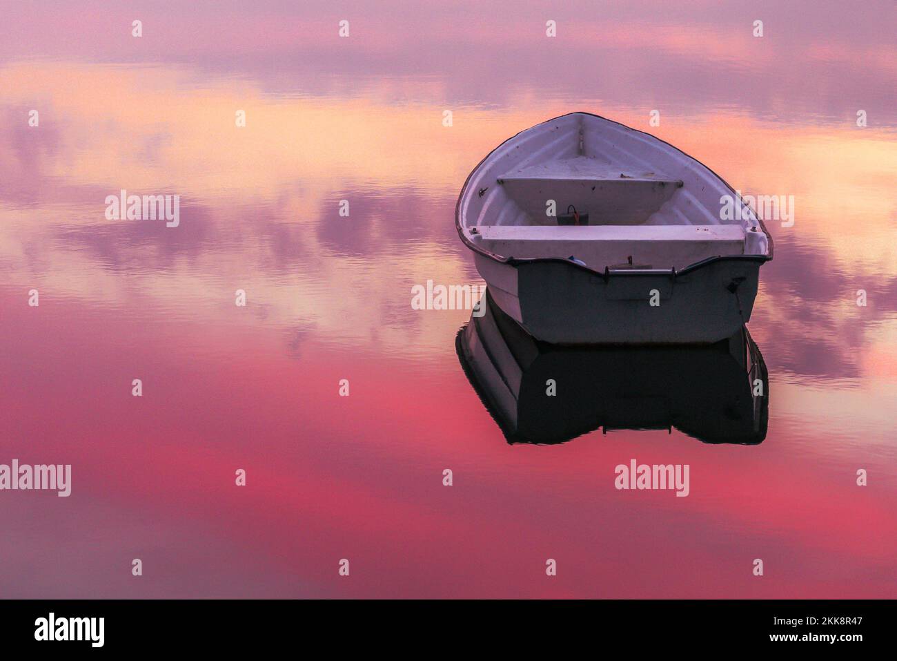Alone boat on water during dusk Stock Photo - Alamy