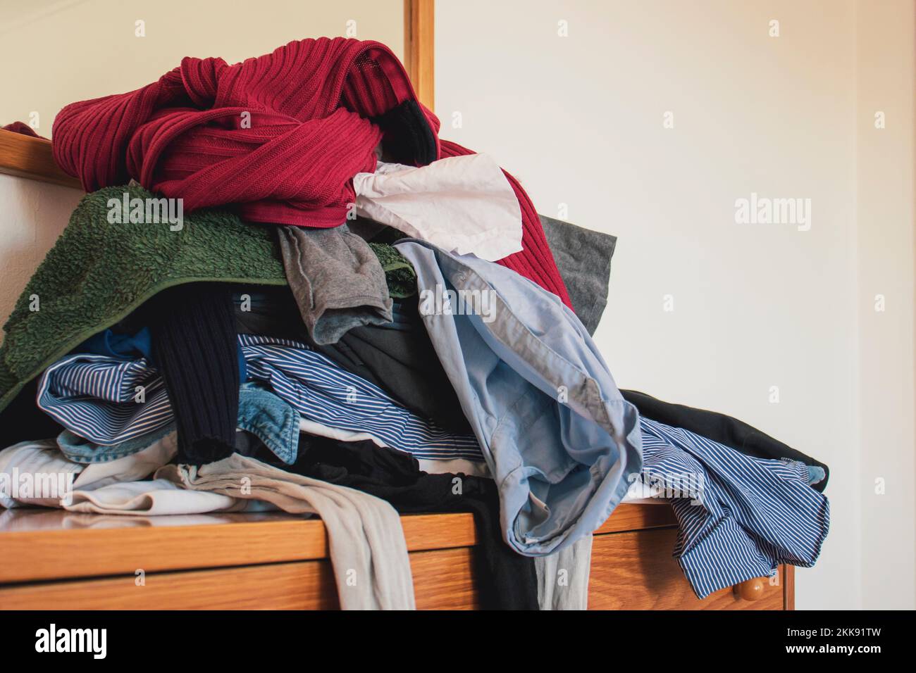 Pile of unfolded clothes on a for laundry on a drawer. Concept of ...
