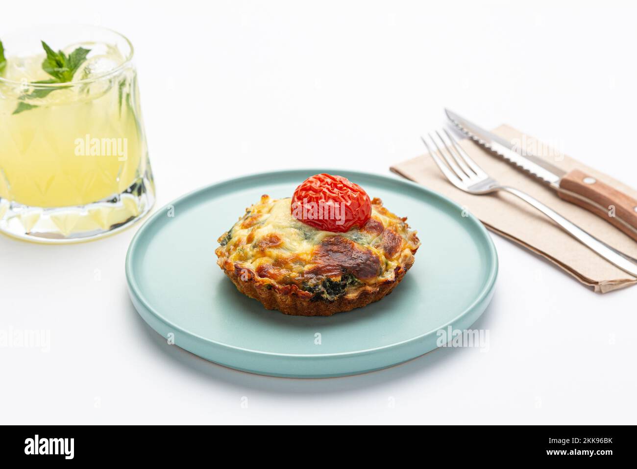 A little pizza pie with a dry tomato on the top, on a white ceramic ...