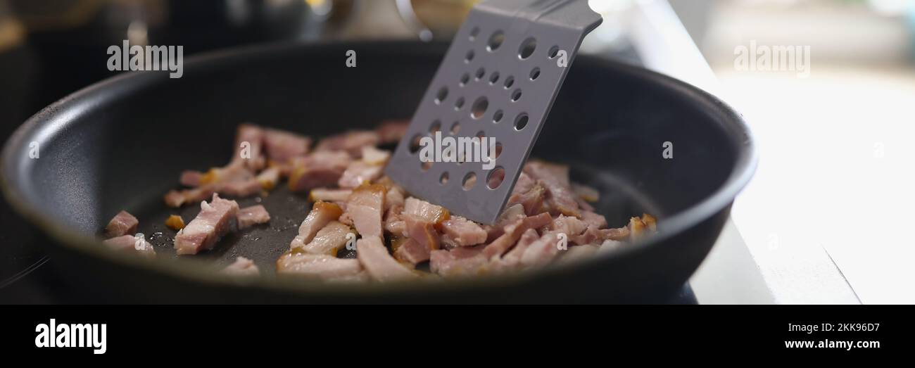 Chef stir ham or bacon slices on hot pan, person frying meat for ...