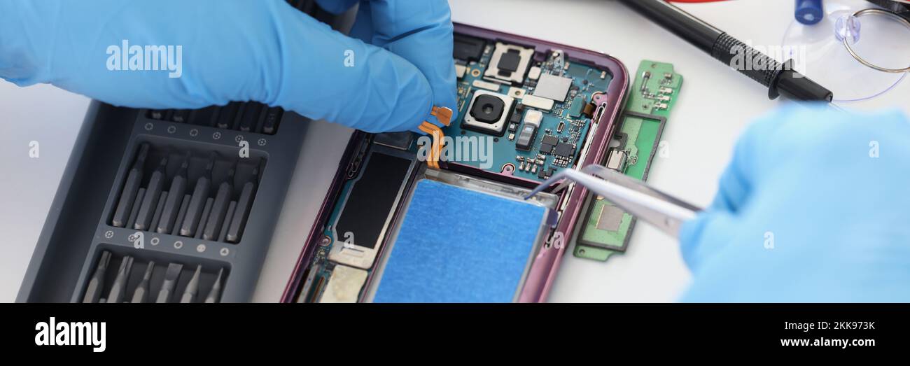 Technician fixing broken mobile phone, set new battery and cover ...