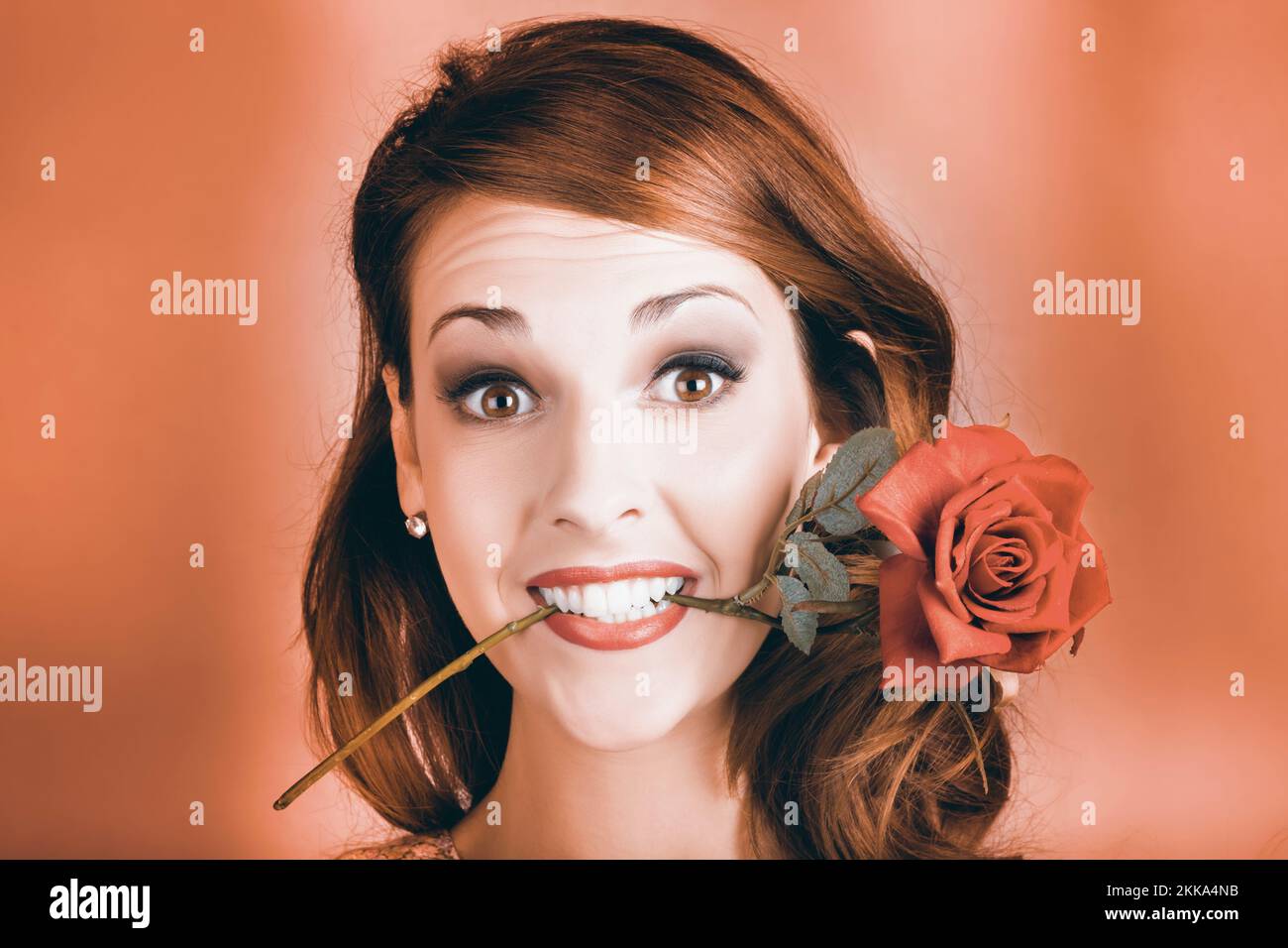 Quirky Face Portrait Of A Shocked Pinup Girl Wearing Vintage Makeup Holding A Red Rose In Mouth