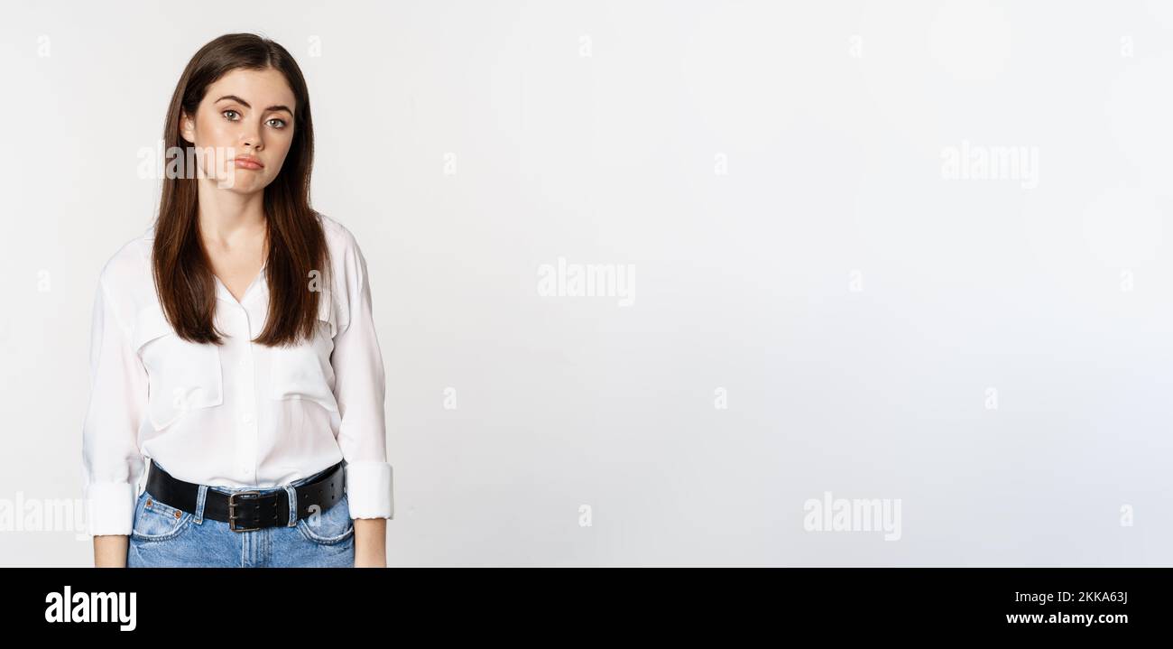 Sad and gloomy woman sulking, looking disappointed and moody, standing ...