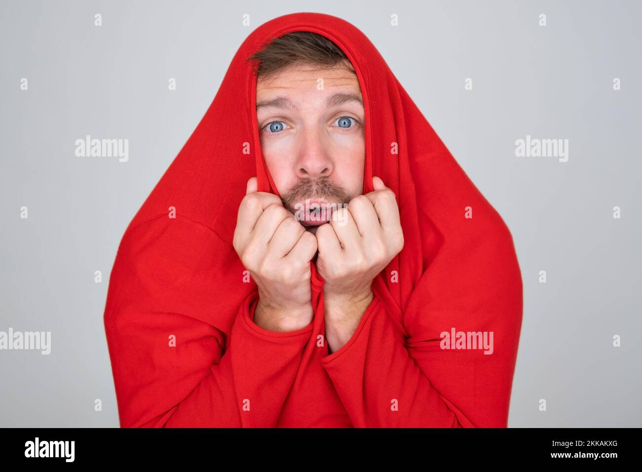 man pulling clothes on head, trying to hide in deep astonishment and ...