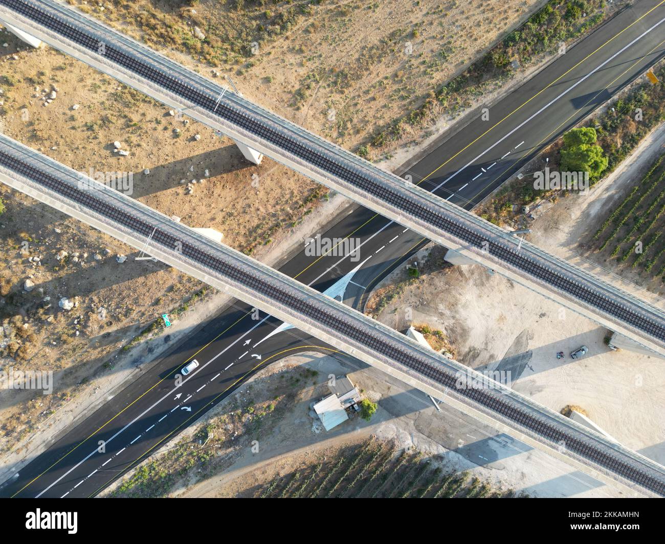 Two long railroad trails on the bridge over the narrow road Stock Photo ...