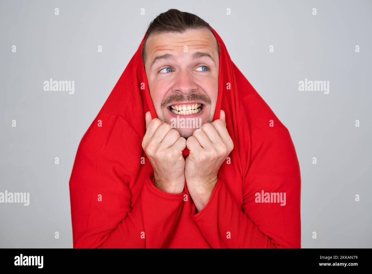 man pulling clothes on head, trying to hide in deep astonishment and ...