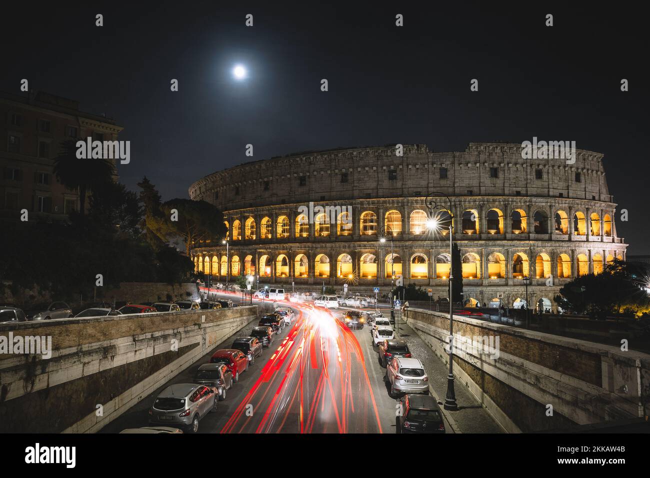 A night view of cars on a road with long exposure and Colosseo in Rome ...