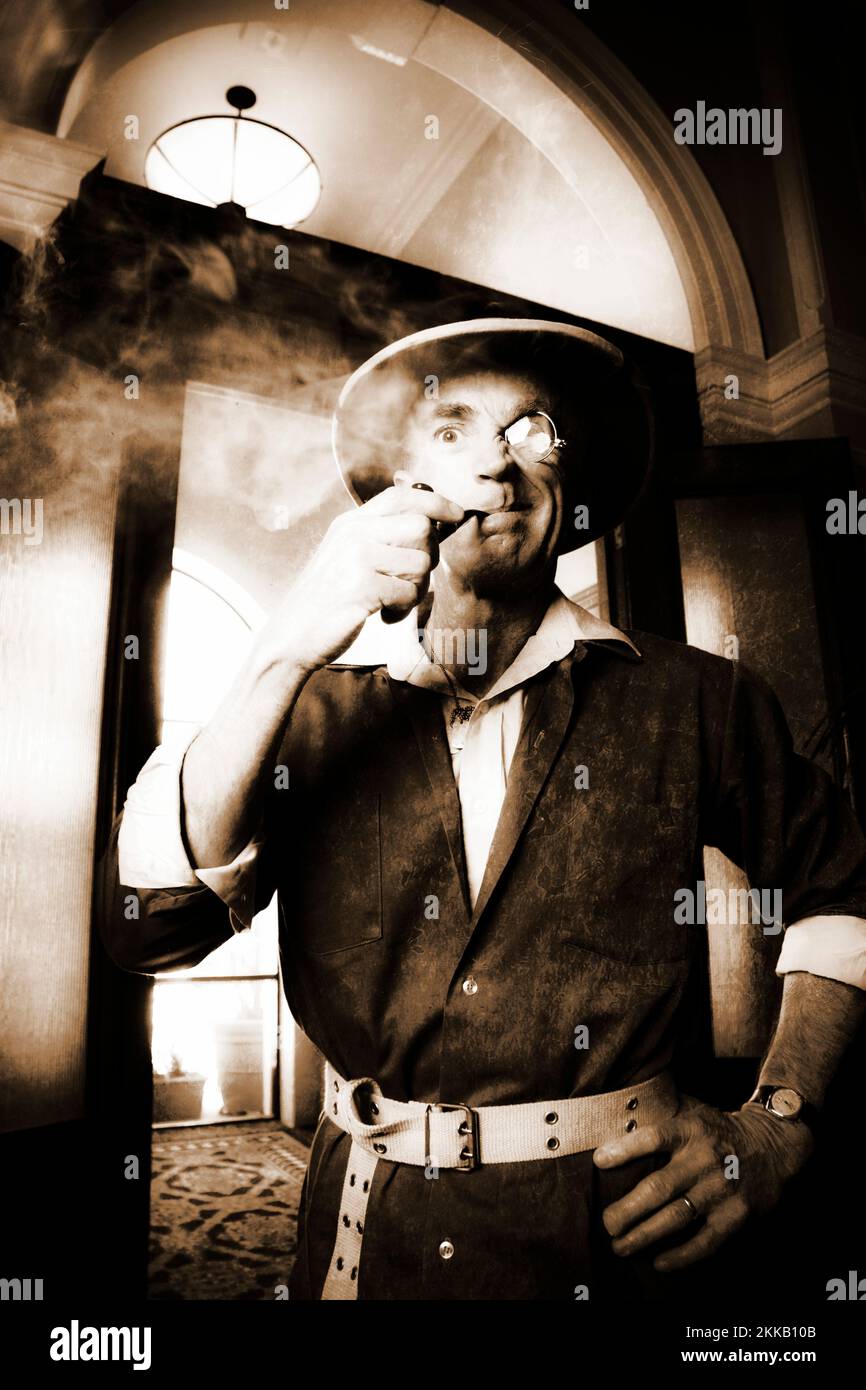 Macho vintage big game hunter or game warden standing with his hand on ...