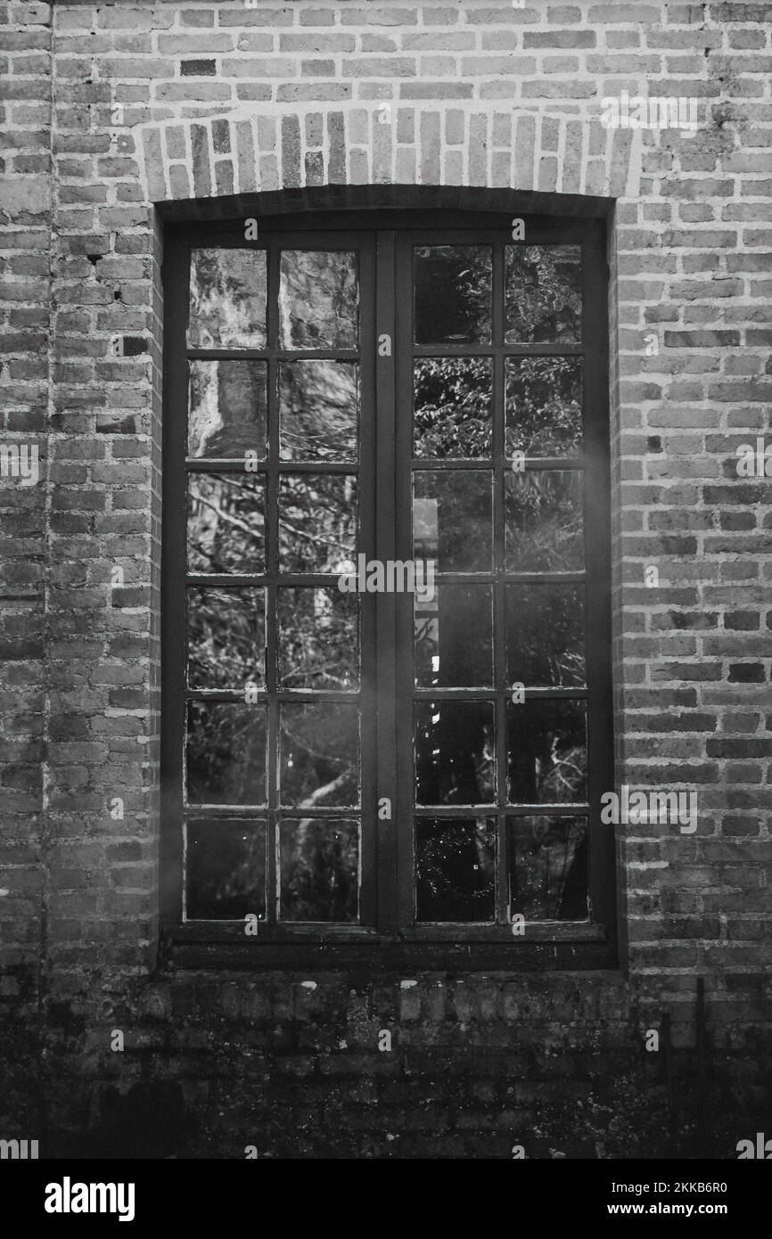 A vertical grayscale shot of a misty house with brick walls Stock Photo ...