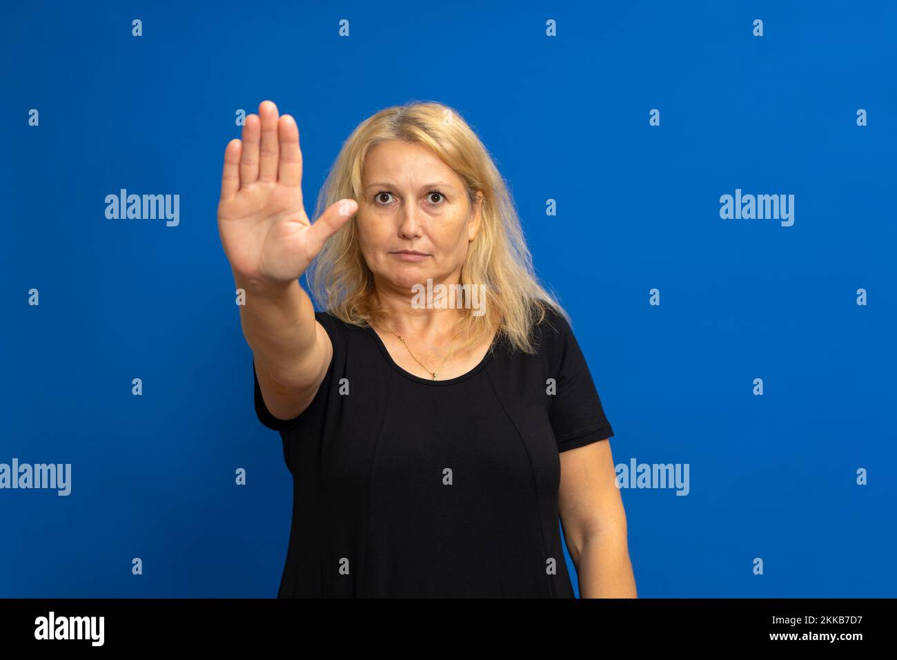 Photo portrait of a frowning caucasian blonde woman showing palm ...