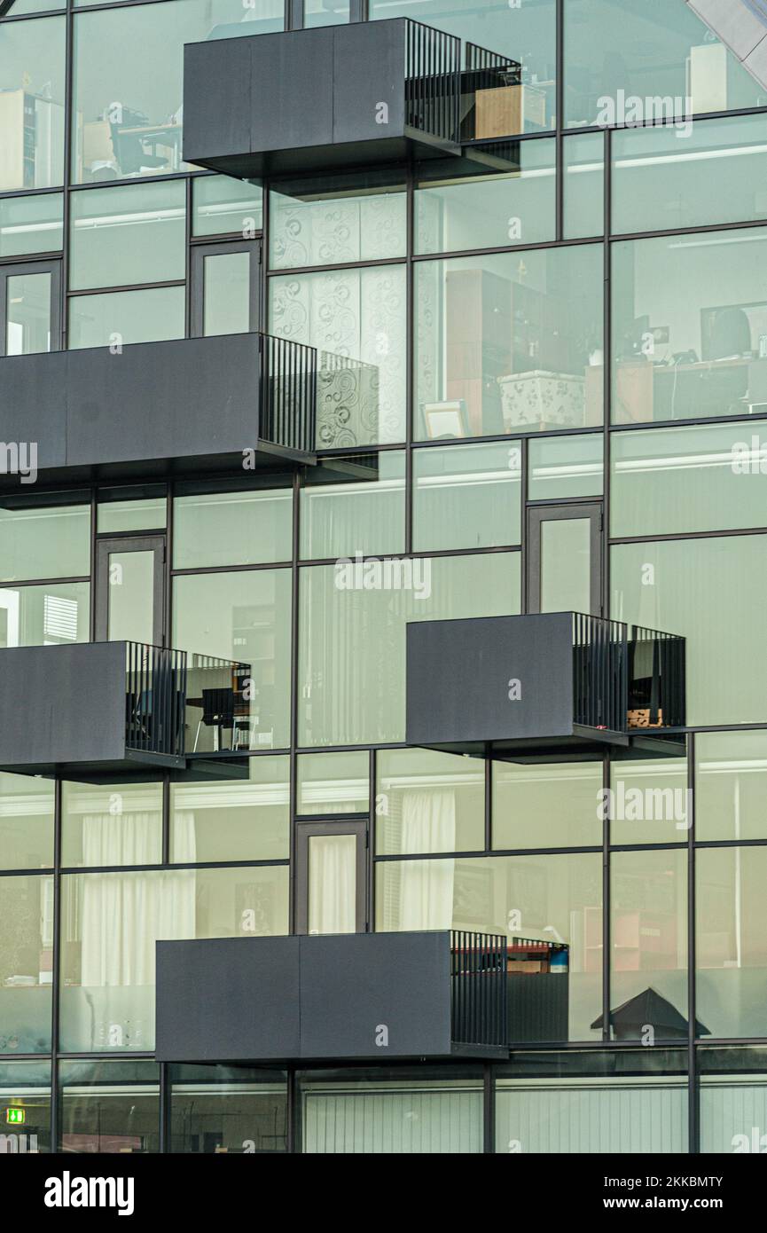 A vertical shot of a modern office building with glass windows and ...