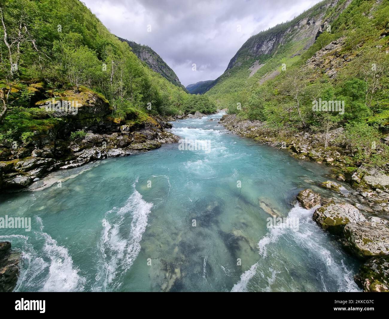 A beautiful shot of a river between mountains on a cloudy day Stock ...