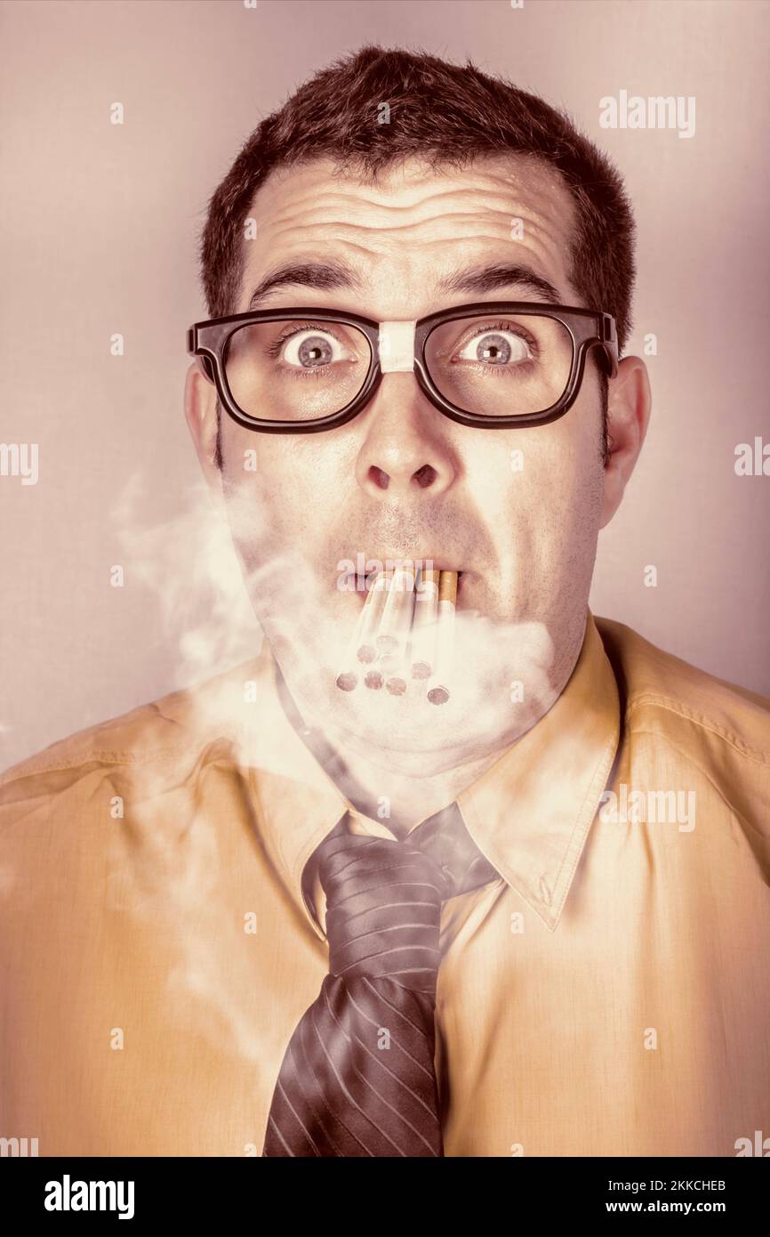 Surprised nerd businessman under stress smoking a pack of cigarettes ...