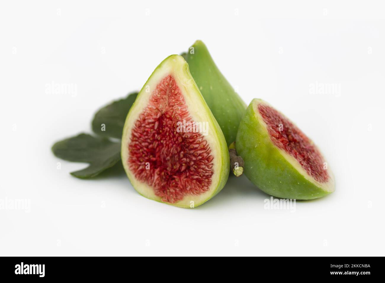 Whole and cut green figs on white background Stock Photo - Alamy