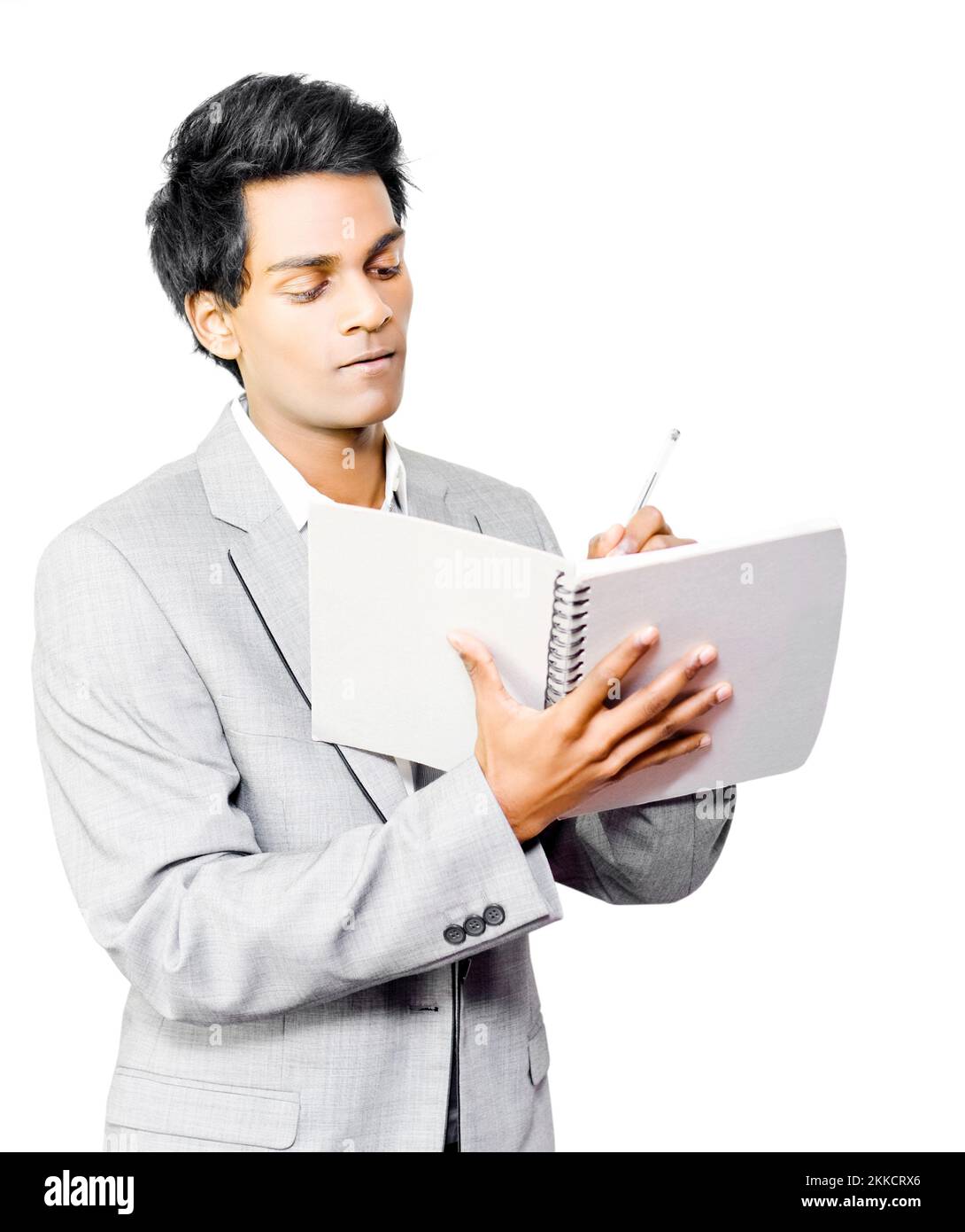 Young Asian businessman taking notes in a wirebound notebook as he ...