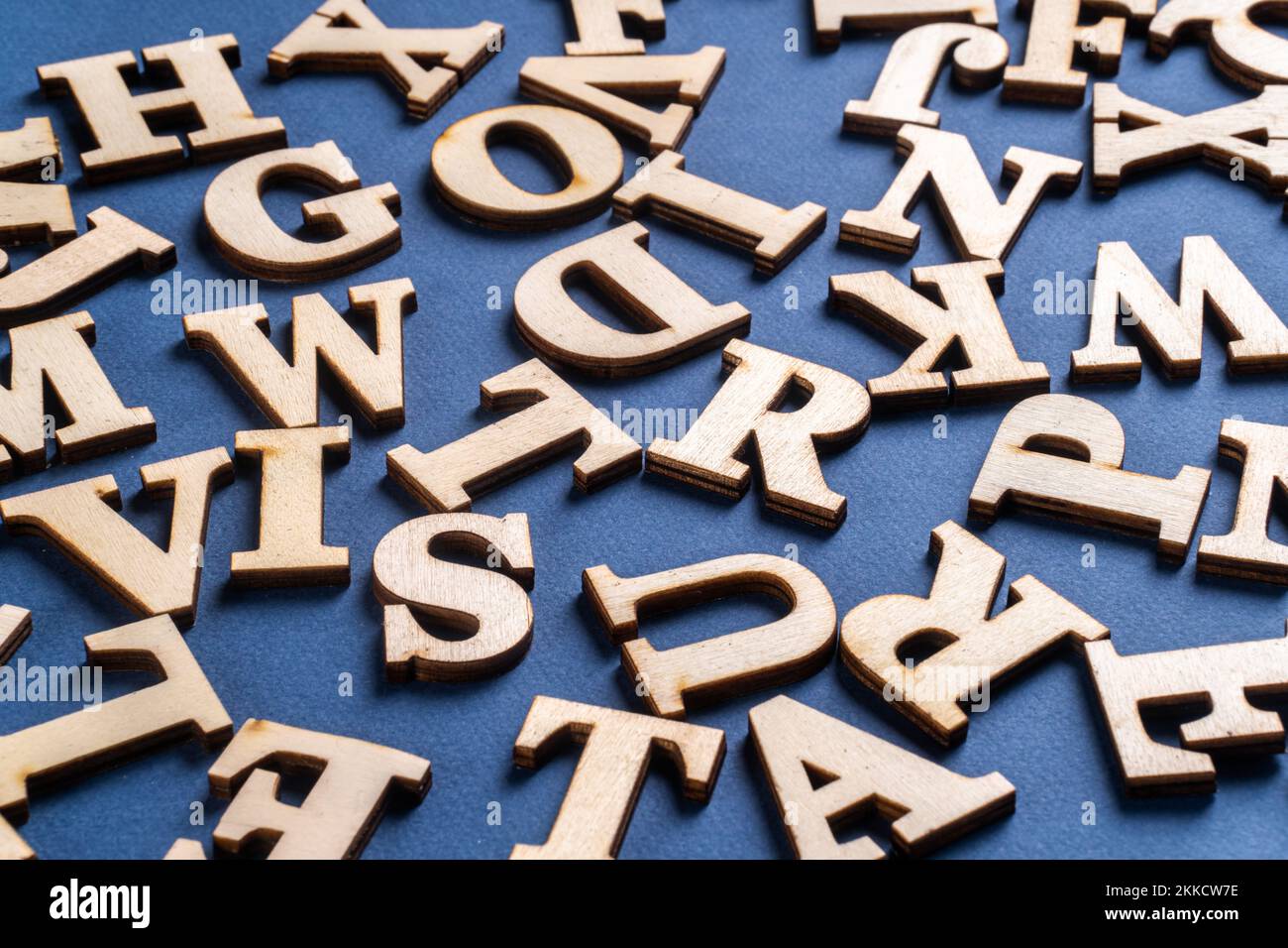 Randomly placed wooden cut alphabet letters on blue background Stock ...