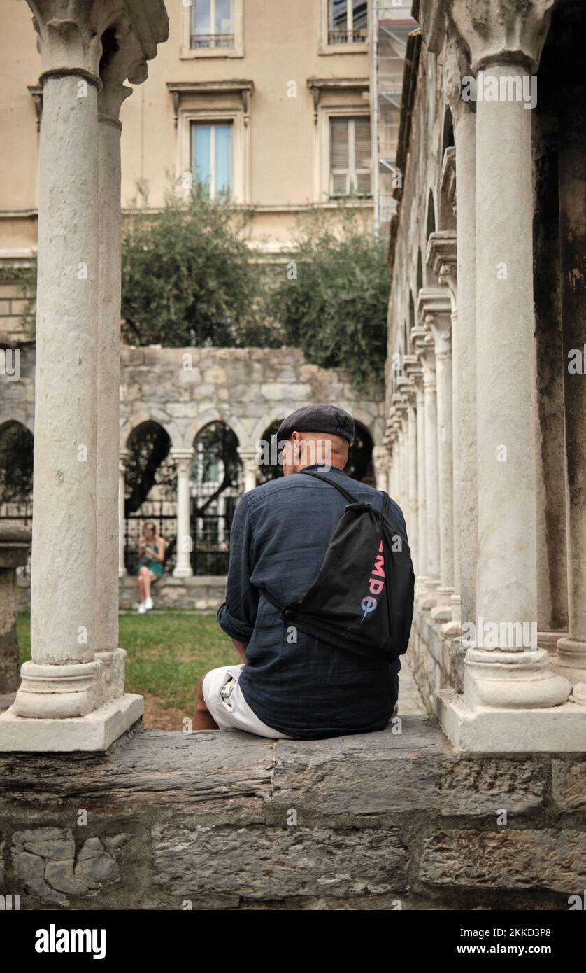 Man sit between columns Stock Photo - Alamy