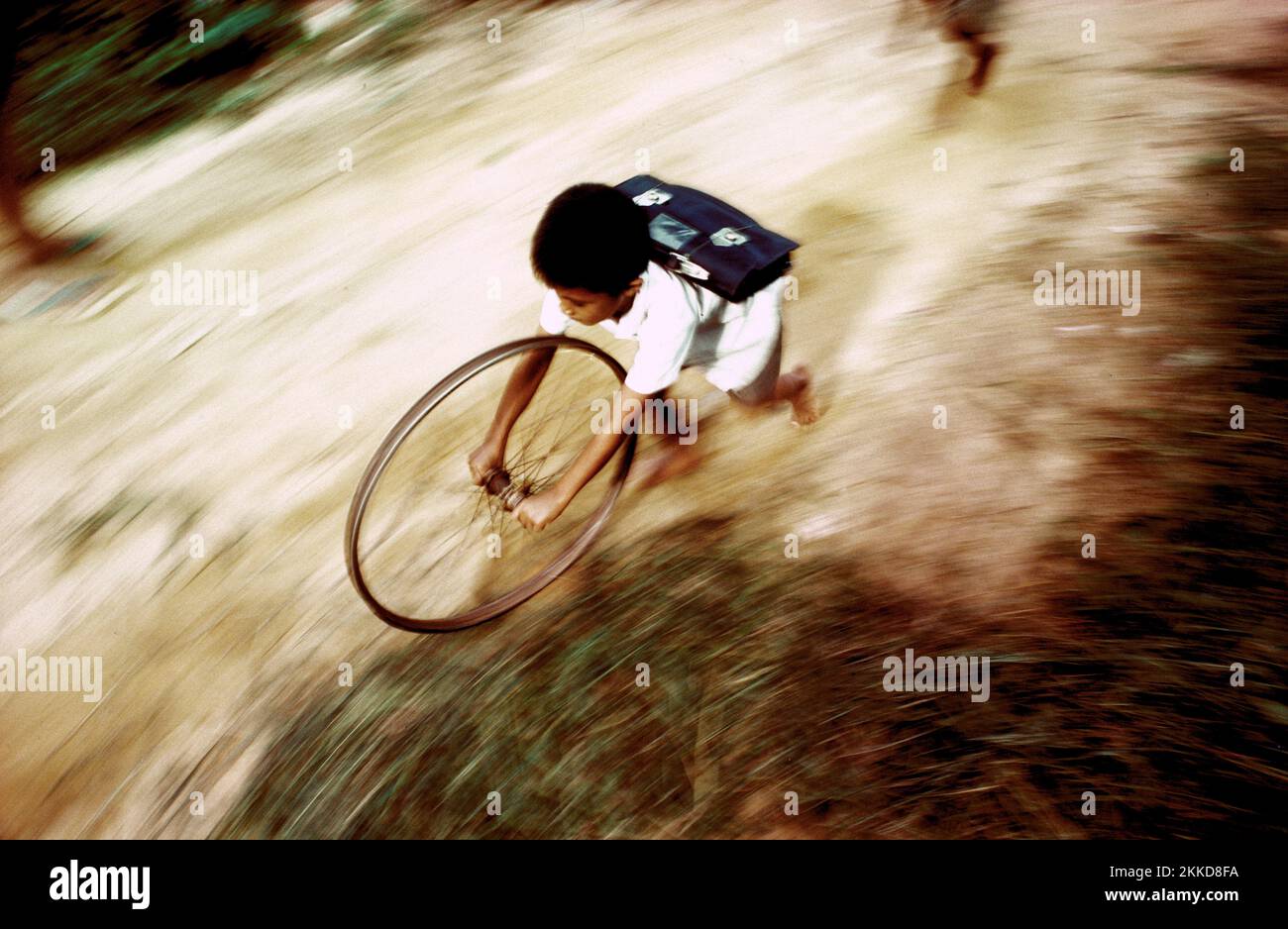 Koh Samet, Thailand - February 5, 2008: boy plays with wheel of bike on ...