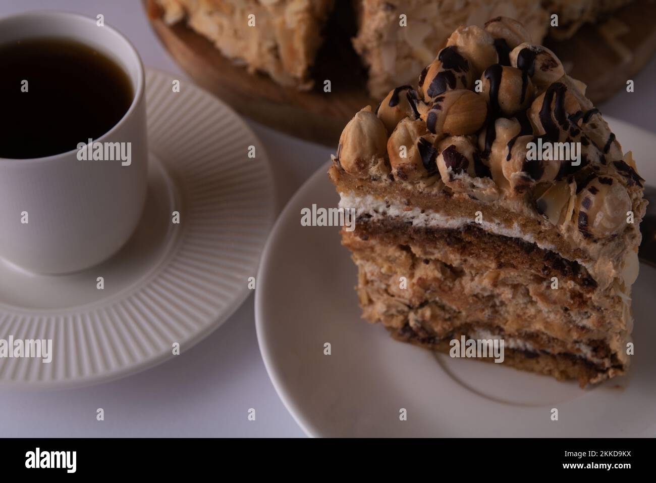 photo of a white cup and a piece of cake cut off Stock Photo - Alamy