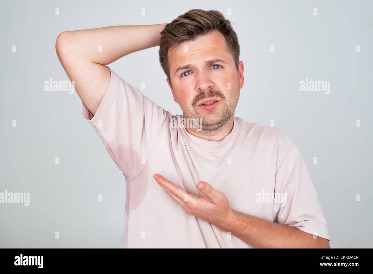 Man with hyperhidrosis sweating very badly under armpit Stock Photo - Alamy