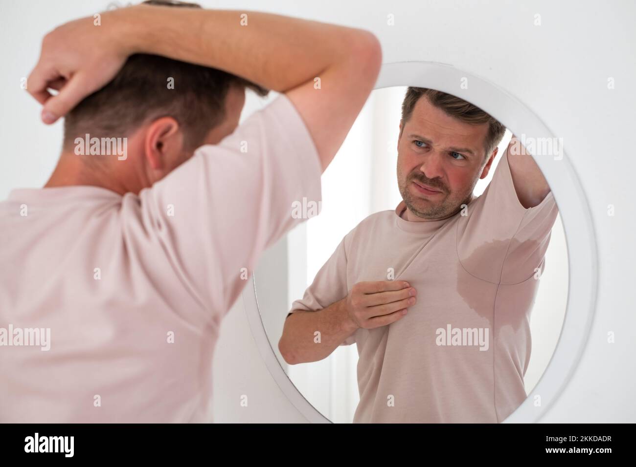 Man with hyperhidrosis sweating very badly under armpit Stock Photo - Alamy