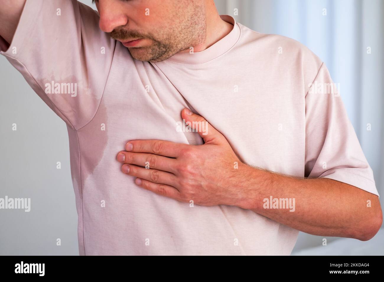 Man with hyperhidrosis sweating very badly under armpit Stock Photo - Alamy
