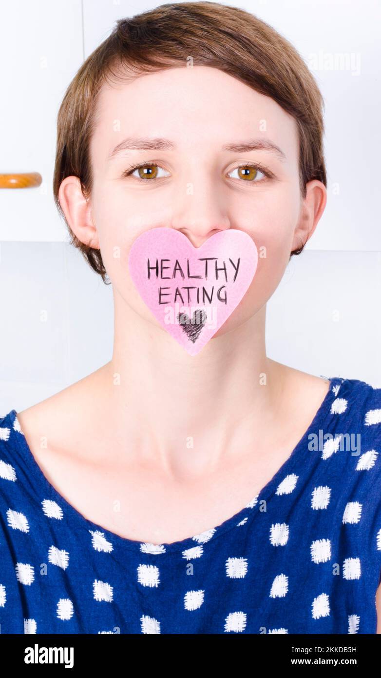 Cute smiling girl with sticky love heart shape note over mouth, healthy ...