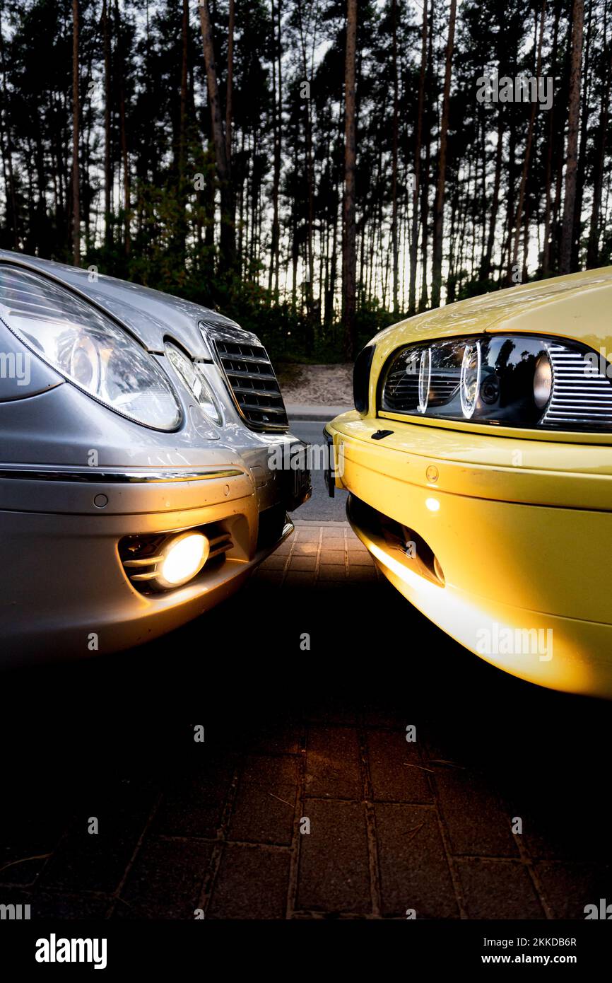 A vertical shot of two cars facing each other with lit headlights Stock ...