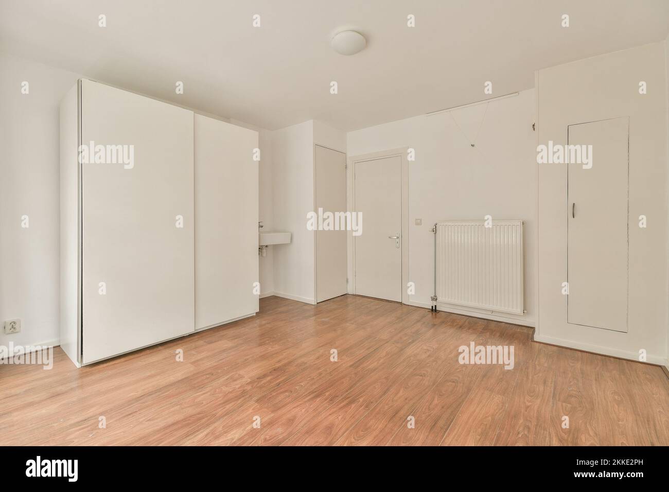 wardrobe and radiator on white wall in empty light room at home Stock ...