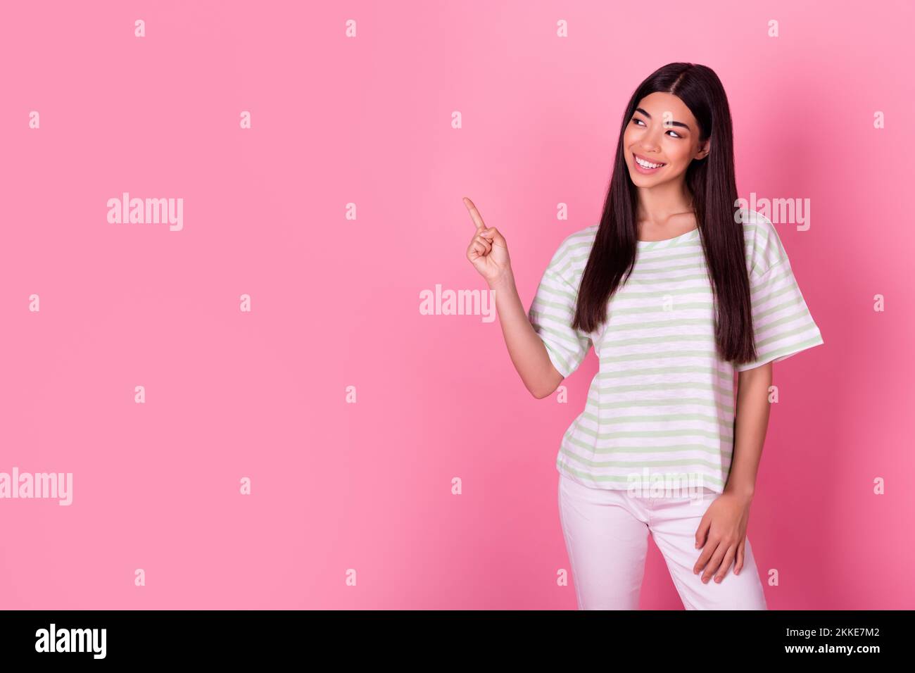 Photo of positive lovely filipino girl look direct finger empty space ...