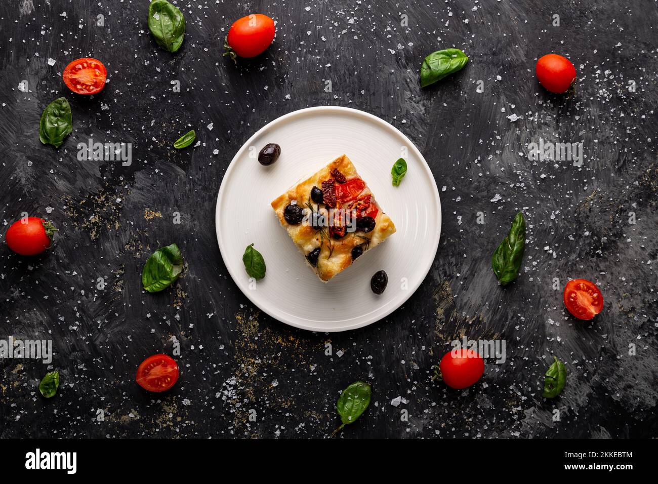 A top view of an appetizing pizza slice cut in square with olives and ...