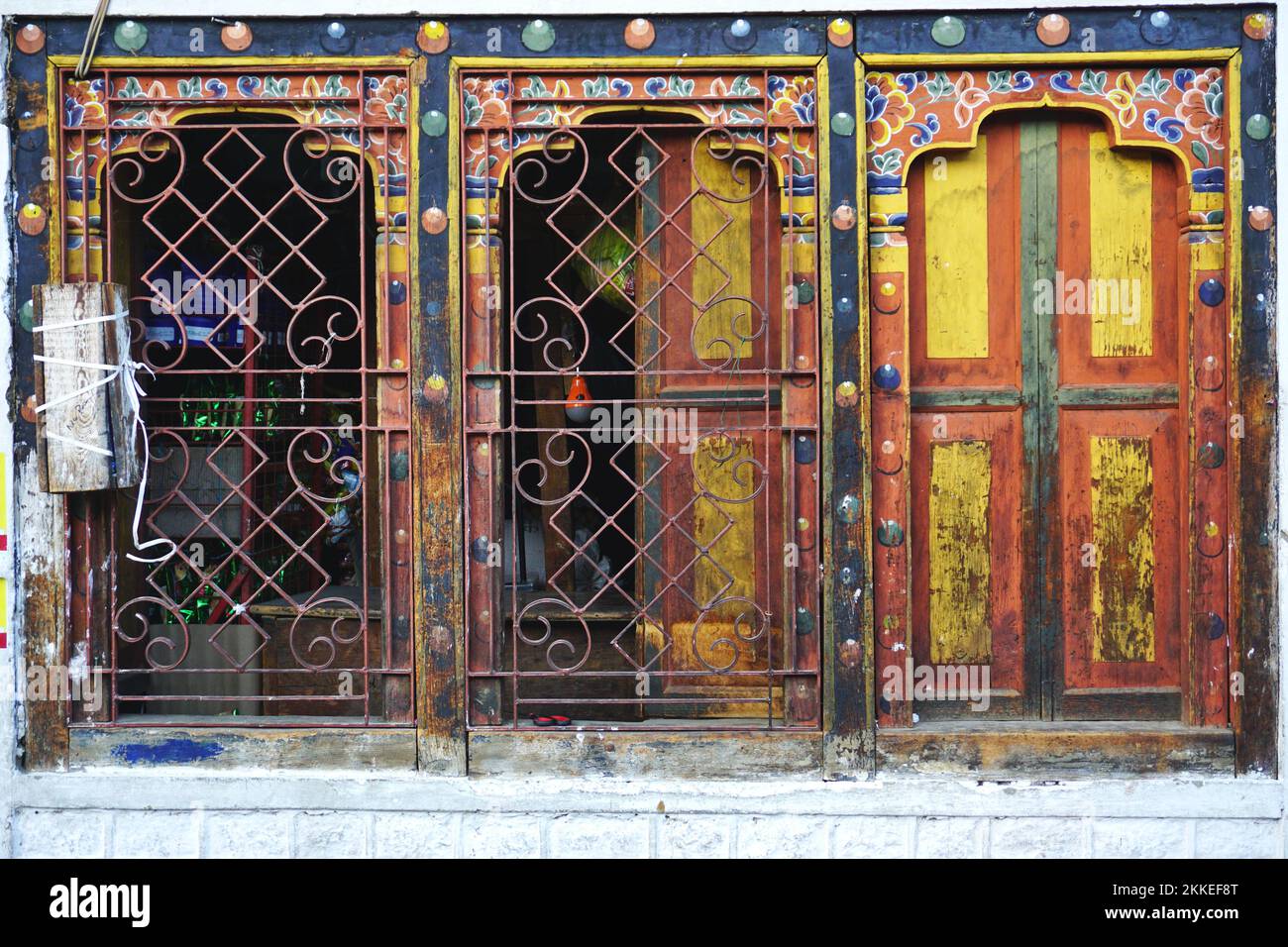 Decorative metal grillwork and vintage painted shutters cover a series ...