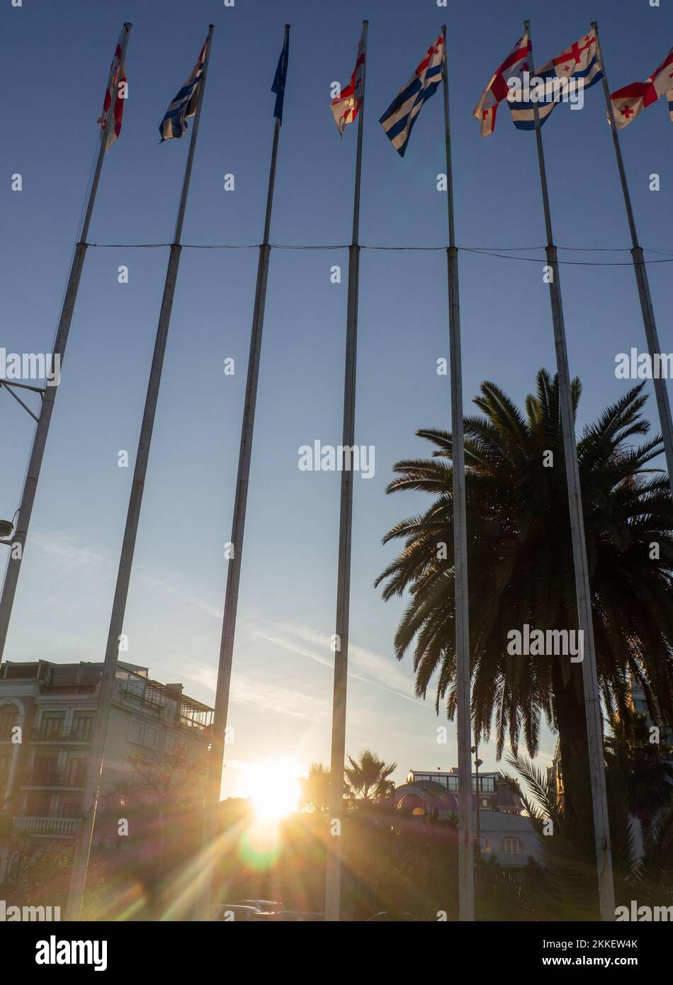 Sunset on the background of flagpoles. State symbols of Georgia ...