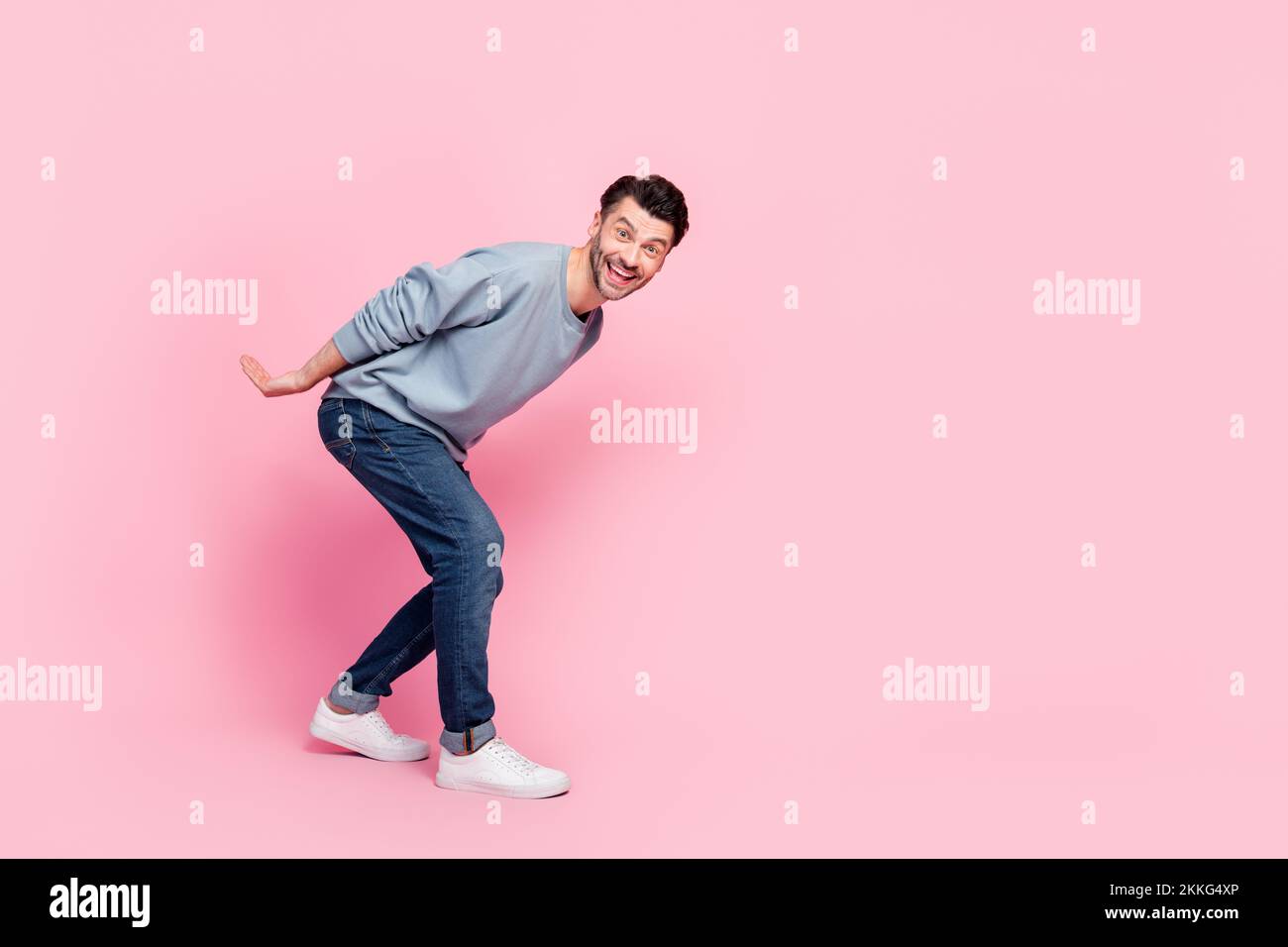 Full size photo of handsome young guy carry heavy invisible box empty ...