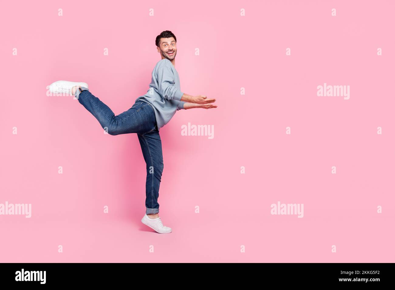 Full length photo of attractive young guy excited carrying invisible ...