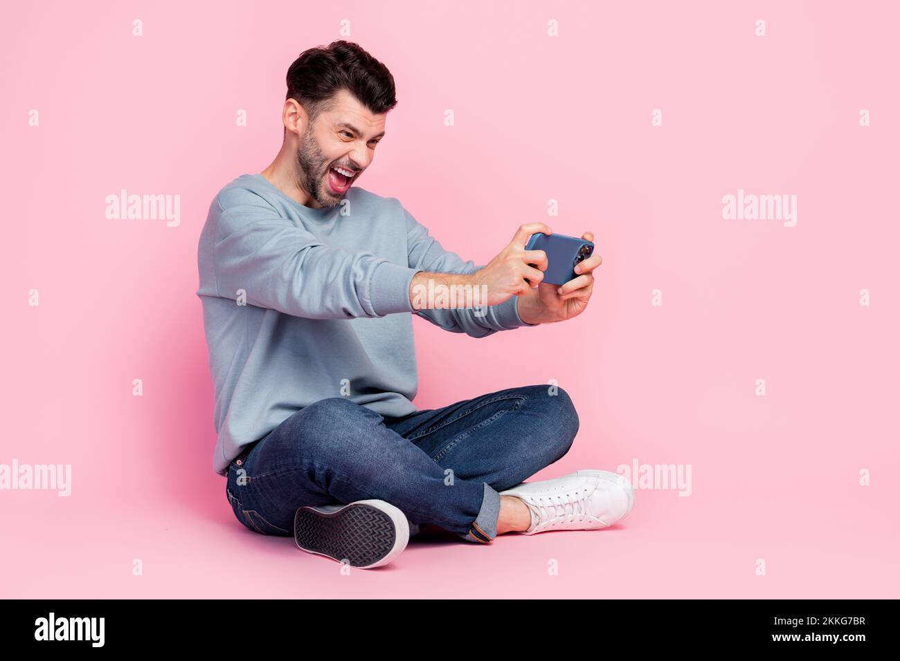 Full body photo of nice young guy hold device horizontally excited ...