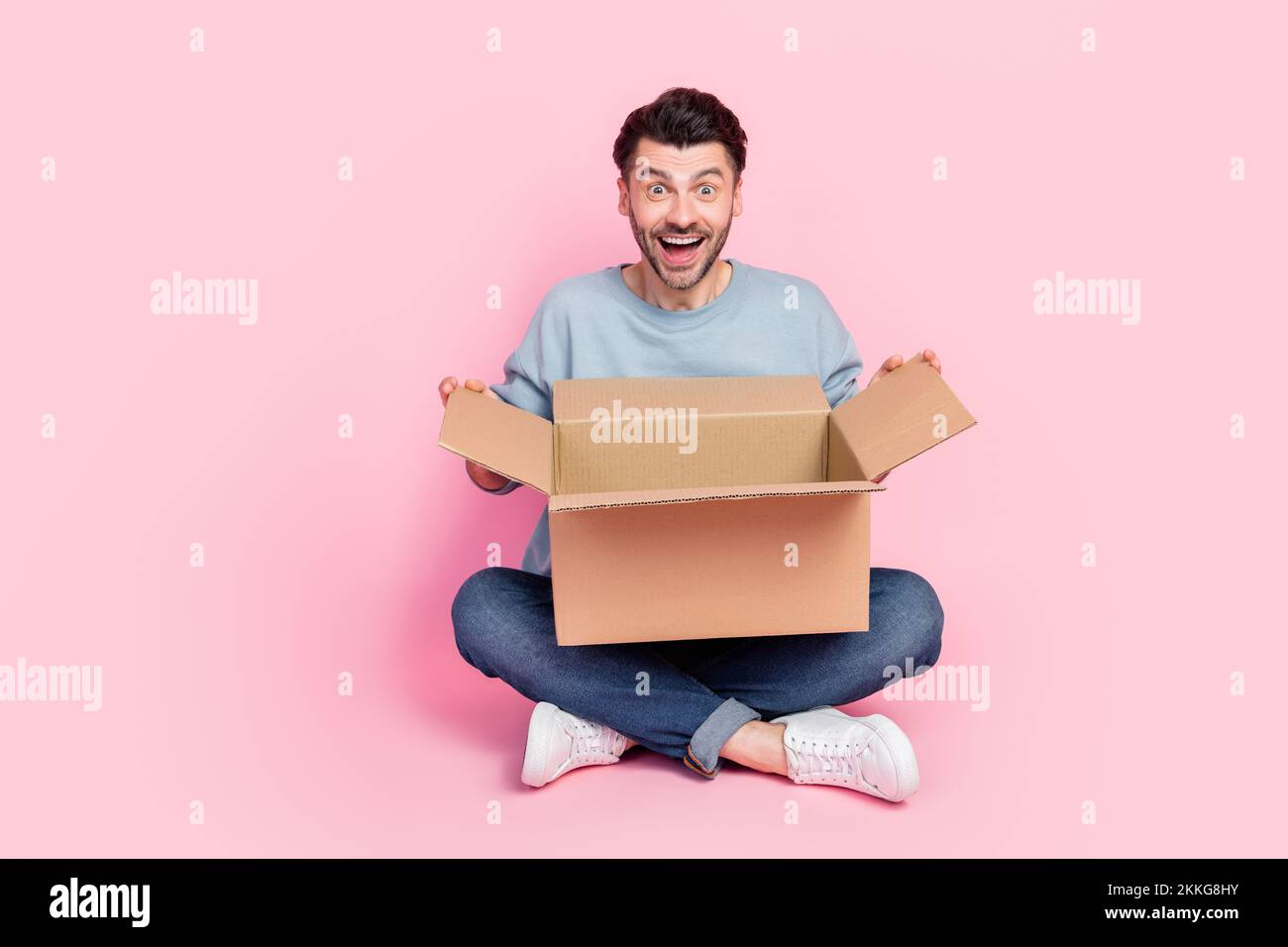 Full length photo of attractive young guy open unpack box receive ...