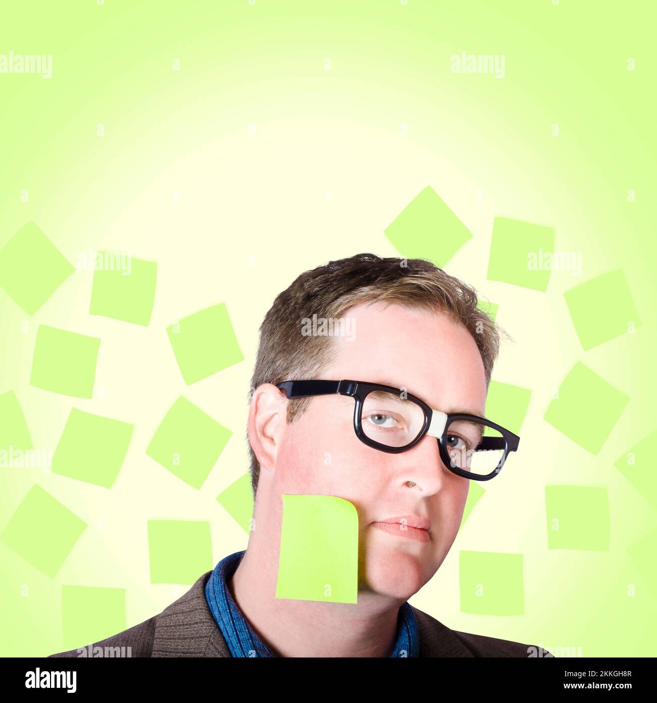 Busy business man wearing reminder note on cheek with a heap of to-do ...