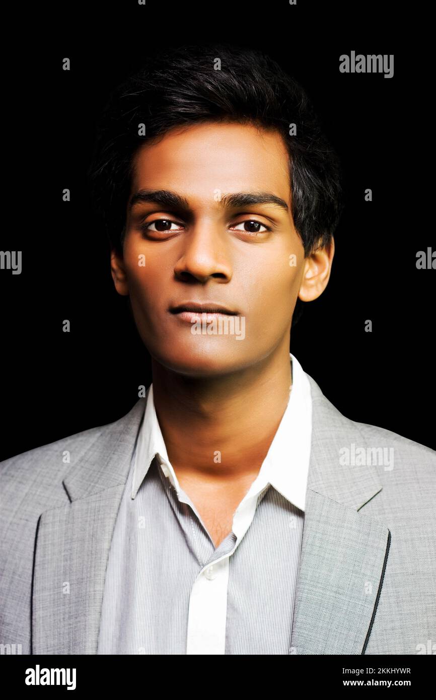 Face of a serious looking Asian business man in suit, with black ...