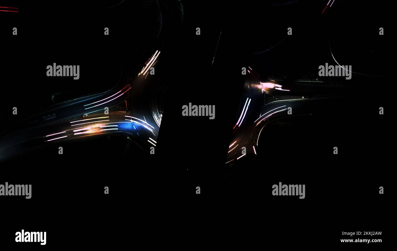 An aerial view of a roundabout road at night with long exposure neon ...