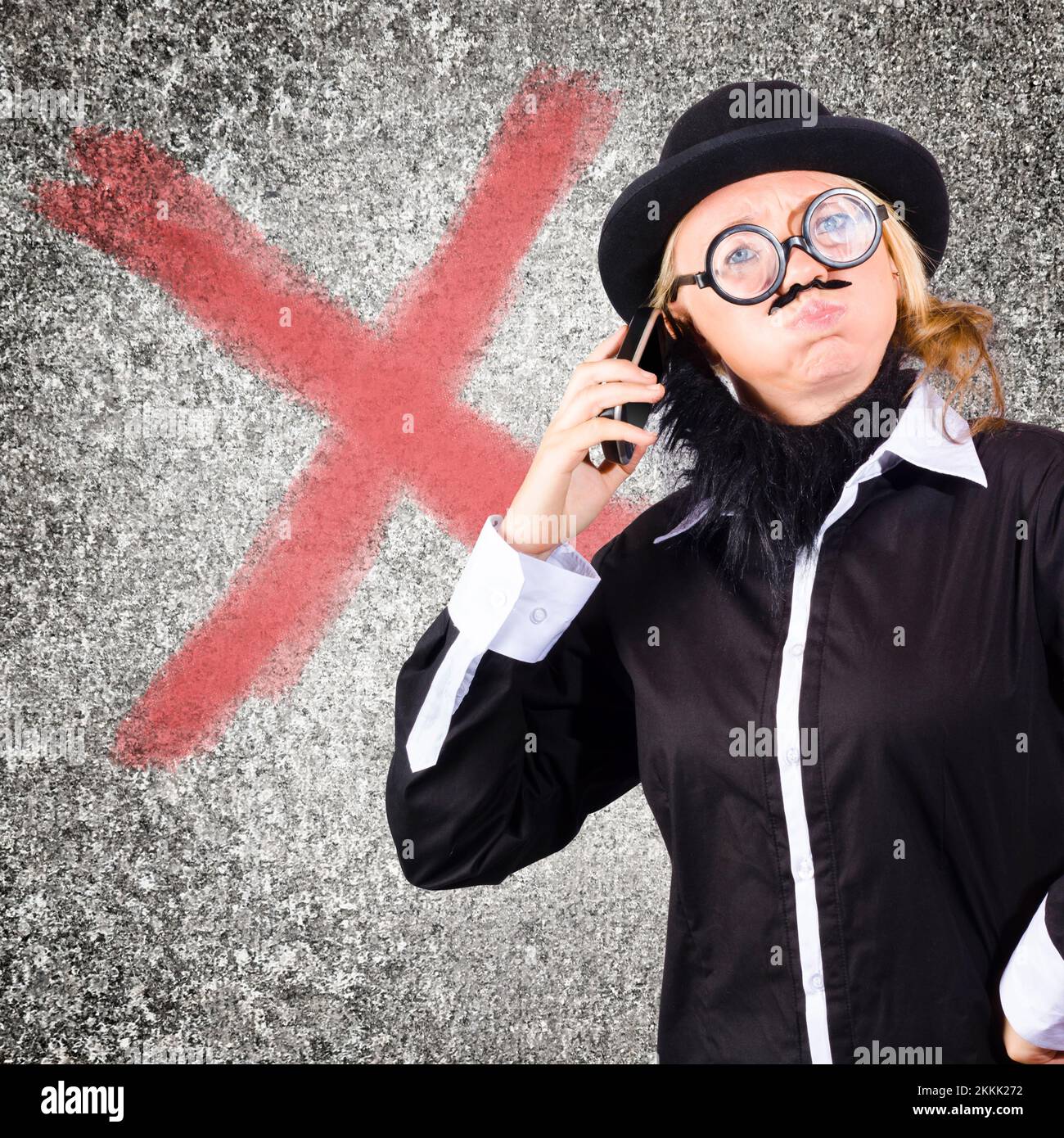 Cross businessman frowning while talking on mobile phone with x ...